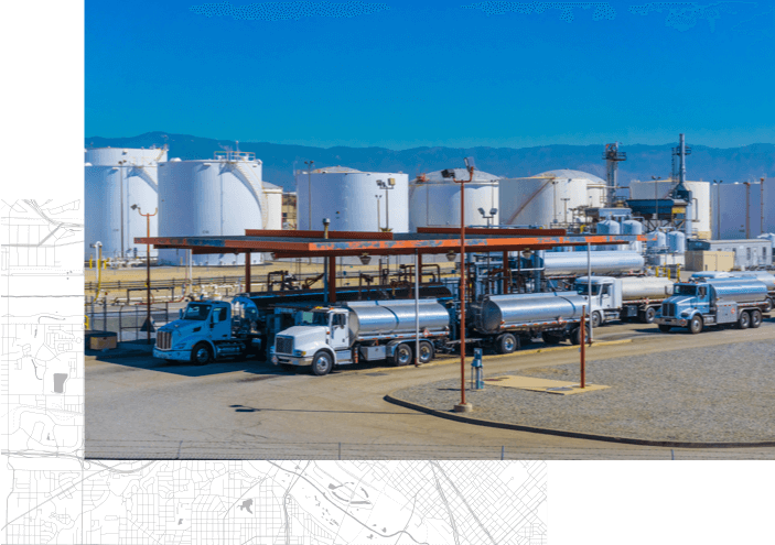 Several fuel trucks fueling up at a rack location.